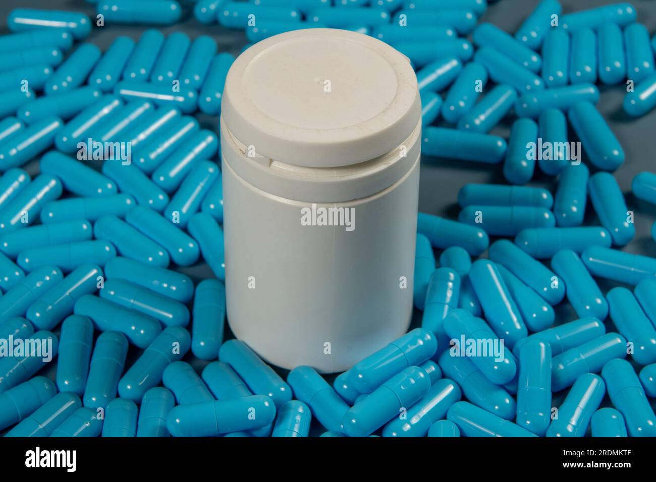 Blue antibiotic capsule pills texture with white bottle. Pharmaceutical ...