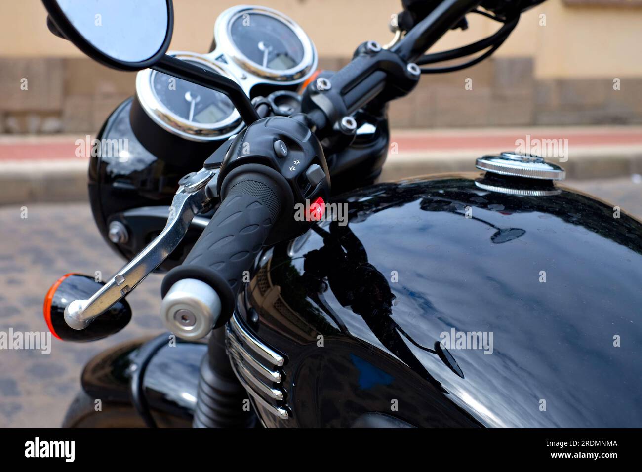 A black modern classic motorcycle, tank, brakes, dials, close details ...