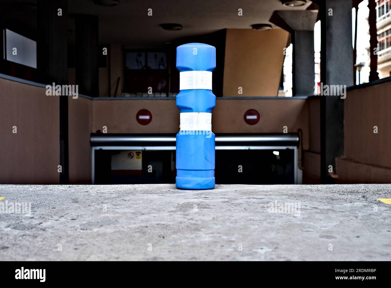 Blue plastic traffic pylon with reflective bands in an entry to ...