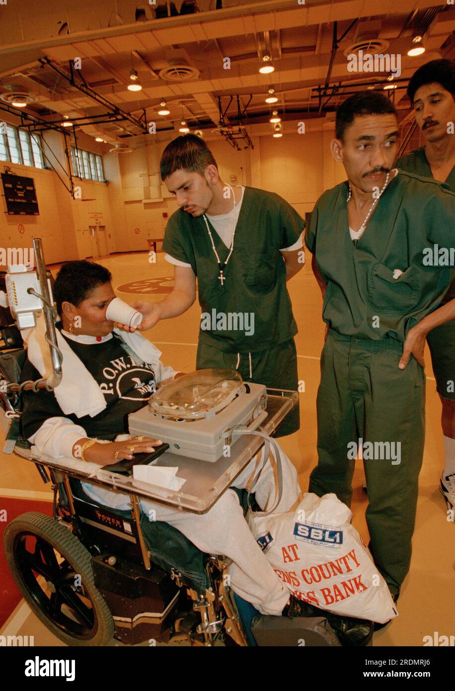 A Rikers Island inmate, Ramon Hernandez, offers a cup of water to Maria ...