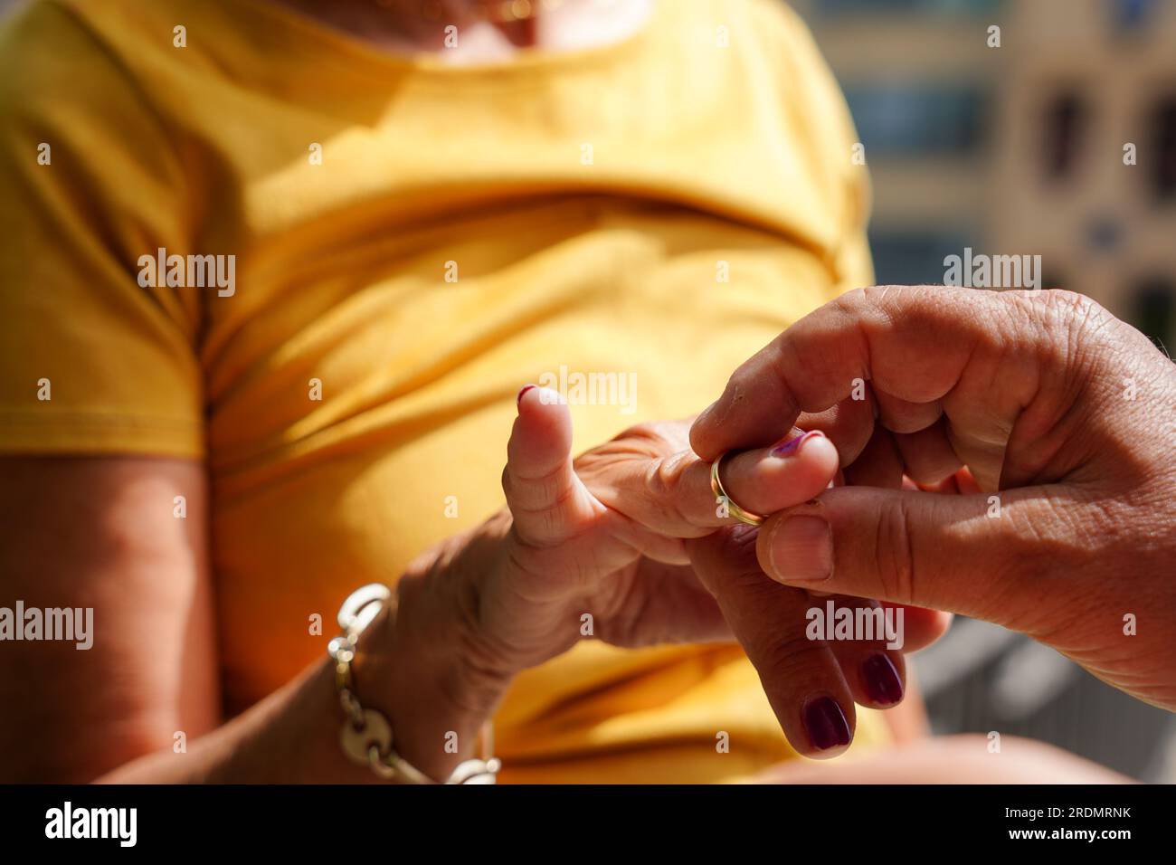 Close-up older person putting engagement wedding golden ring to a woman ...