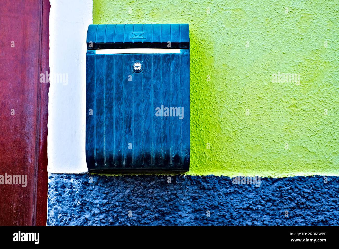 Dark blue mailbox on a colorful wall Stock Photo - Alamy