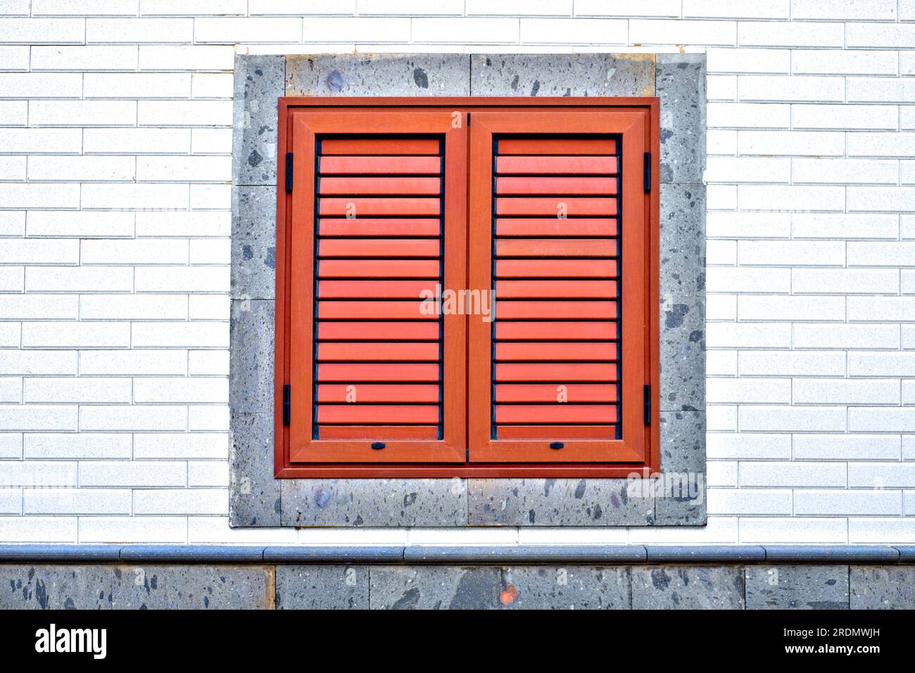 Bright brown closed window shutters in a white wall, architecture home ...