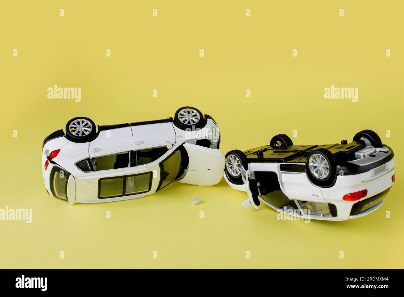 Two mini toy car crash on yellow background, incident, car traffic ...