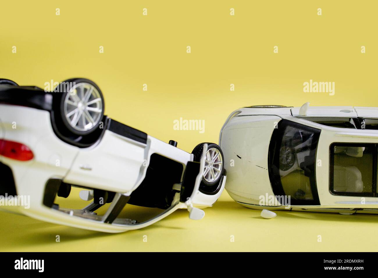 Two mini toy car crash on yellow background, incident, car traffic ...