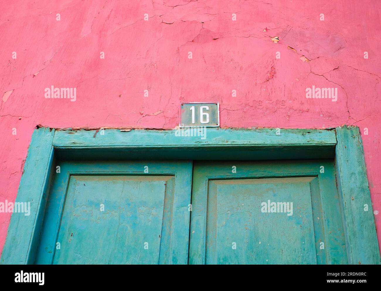 Pastel emerald green door in bright pink wall, architecture detail of ...