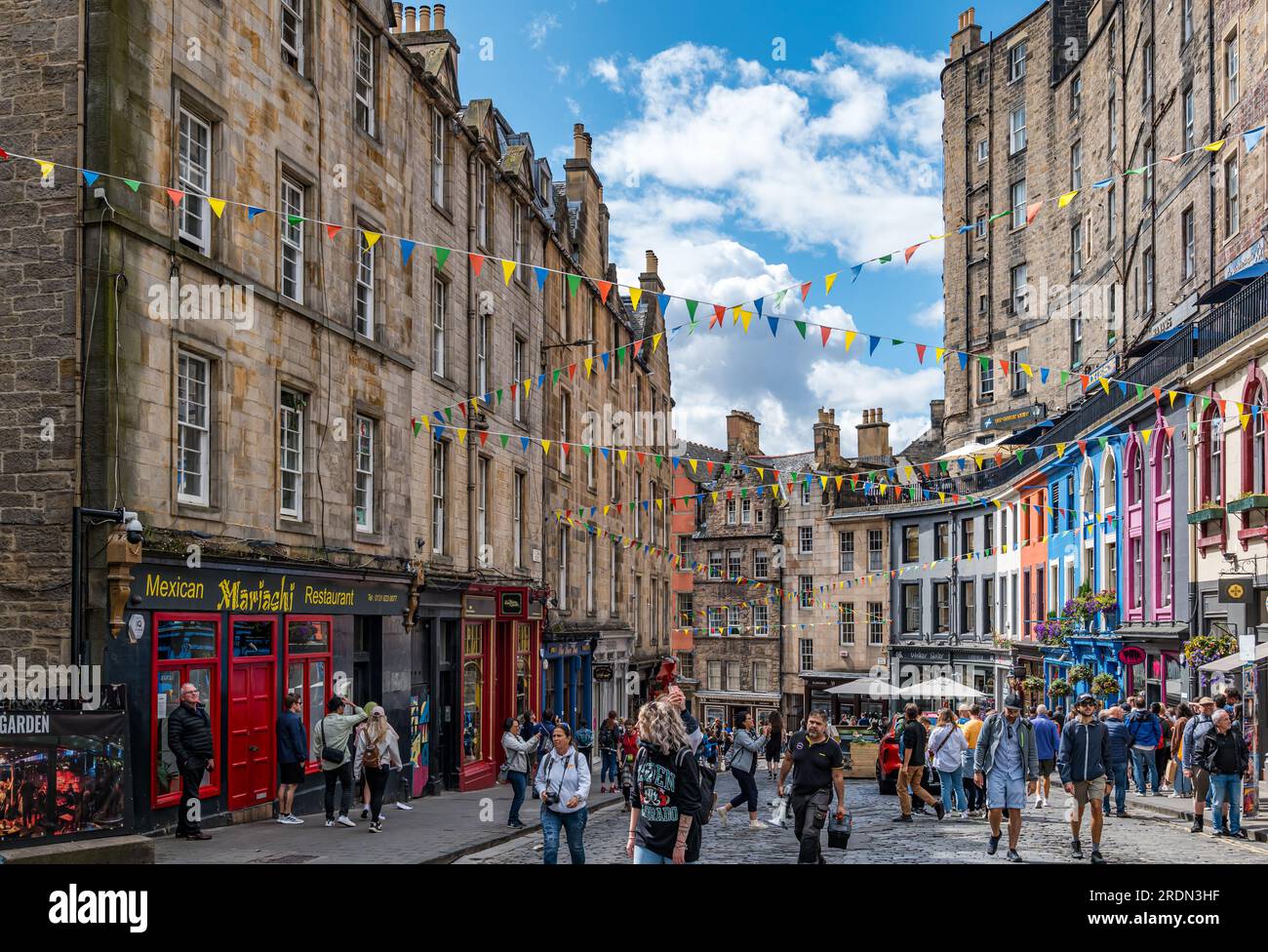 Crowd of people in Victoria Street with view down cobbled street with ...
