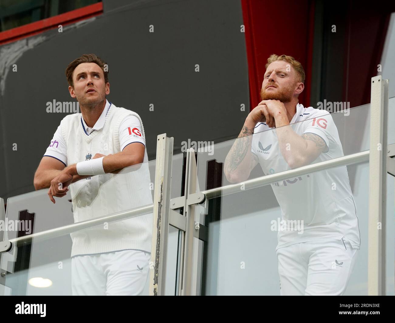 England's Stuart Broad (left) and Ben Stokes look out from the players ...
