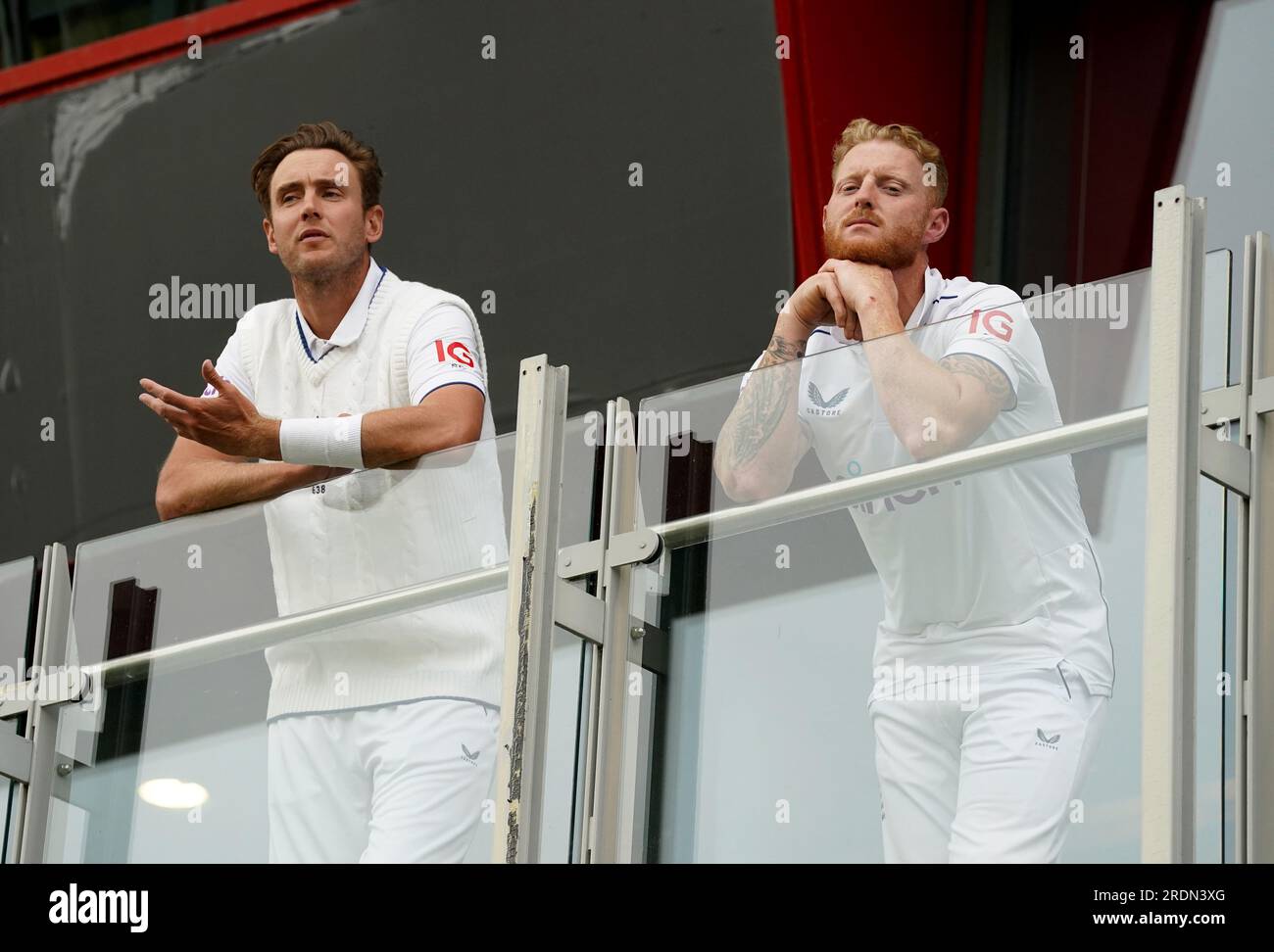England's Stuart Broad (left) and Ben Stokes look out from the players ...