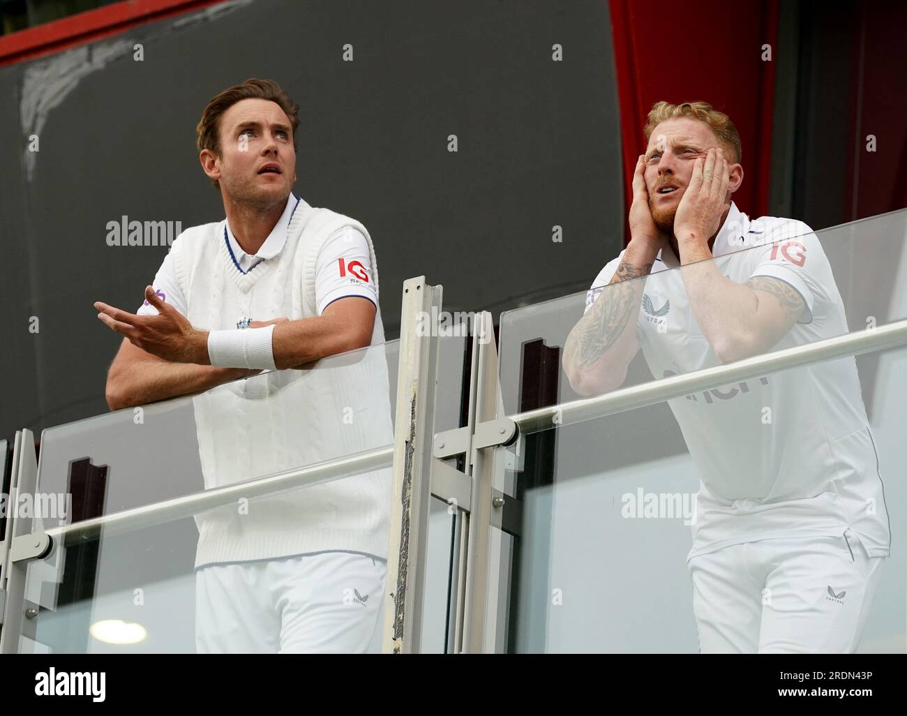 England's Stuart Broad (left) and Ben Stokes look out from the players ...