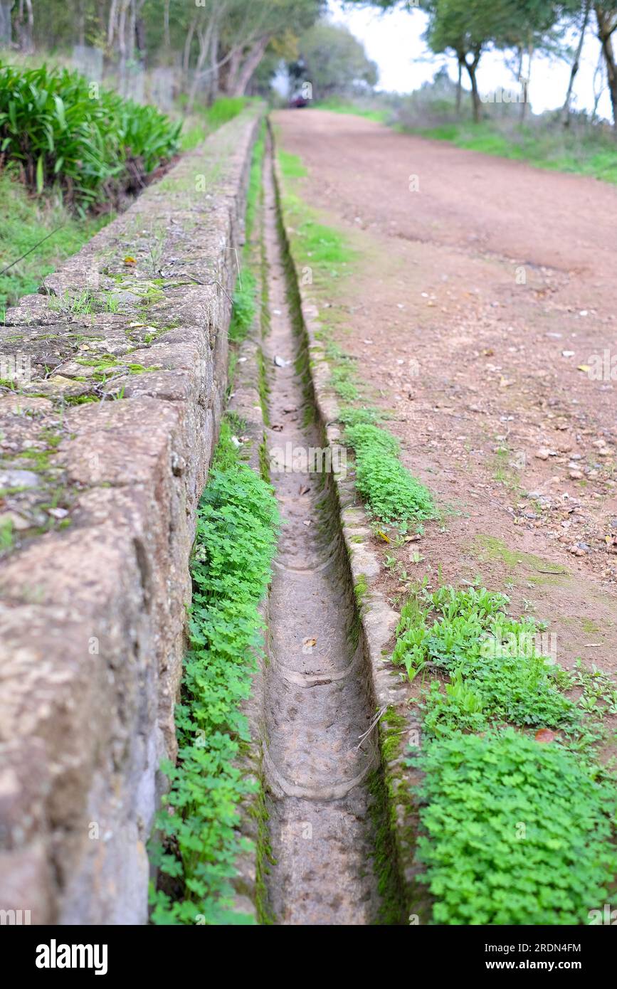 Old aqueduct and a stone wall at the edge of a country road Stock Photo ...