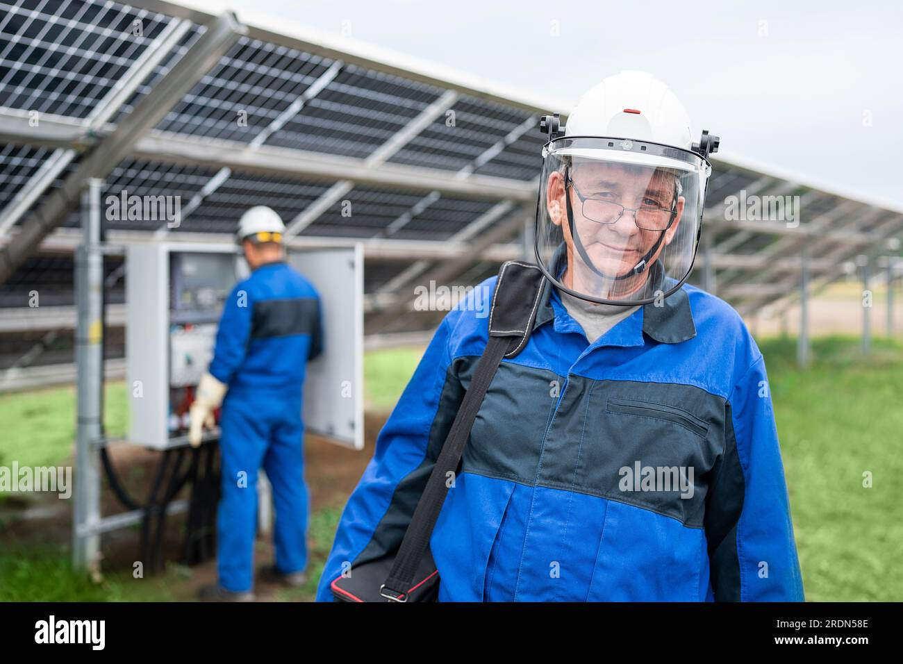 Mature Service Engineer man standing in front of solar panels ...