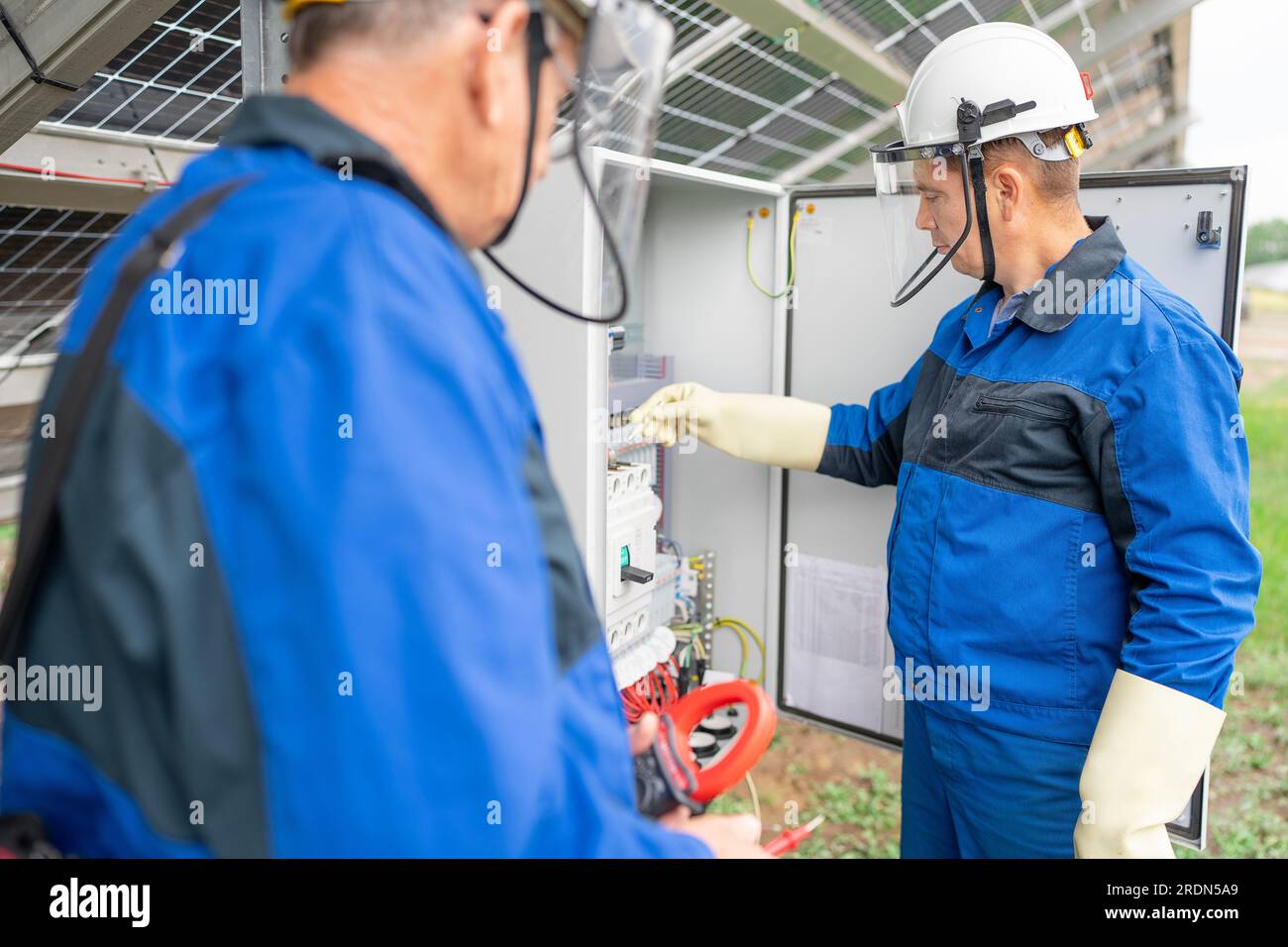 Two Service Engineers or electrician working on checking transformer ...
