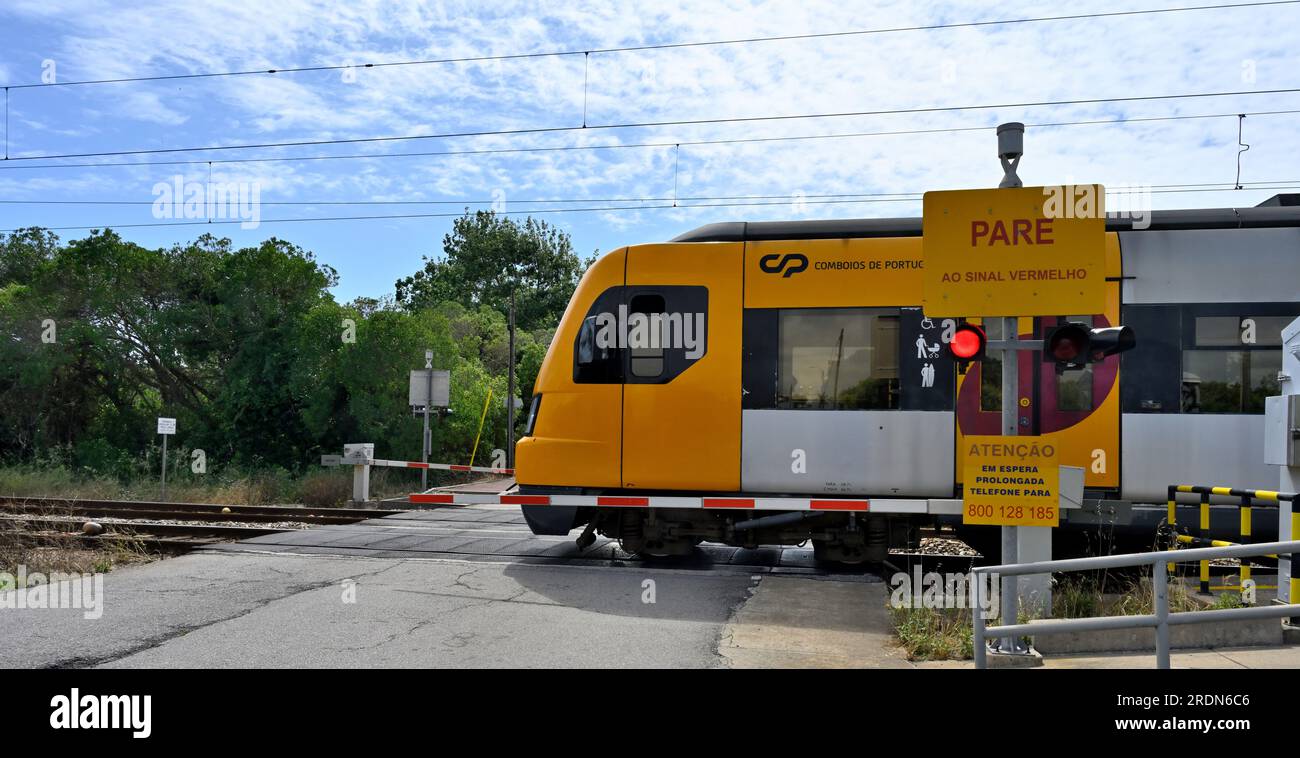 Level crossing with train travelling over the road and signals showing ...