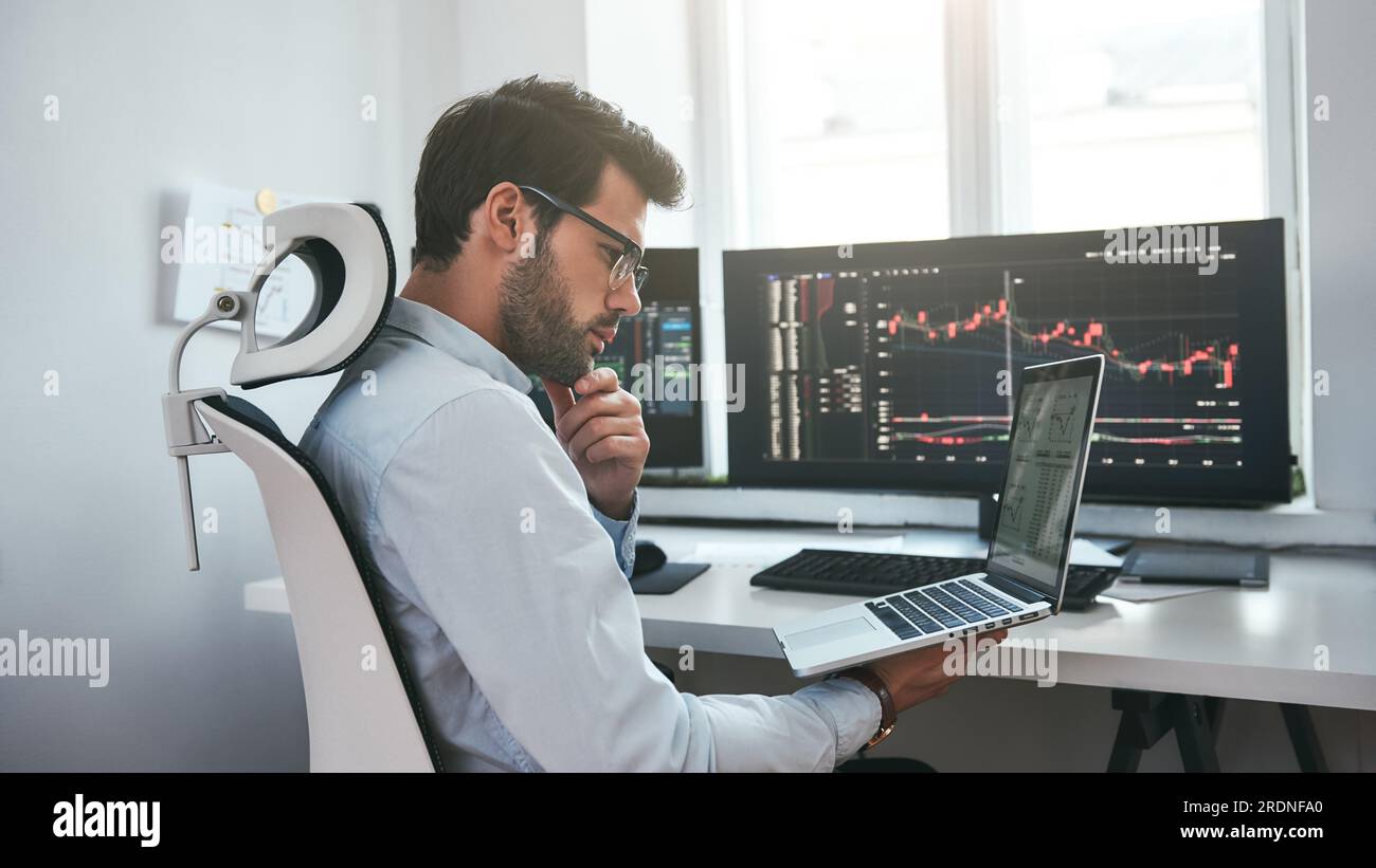 Busy day. Professional male trader wearing eyeglasses analyzing ...