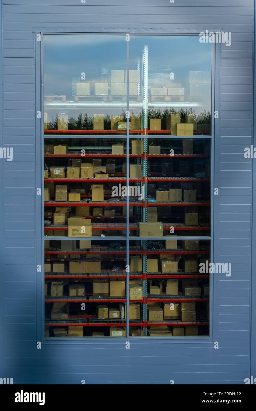Boxes and pallets visible through a window at a large warehouse Stock ...