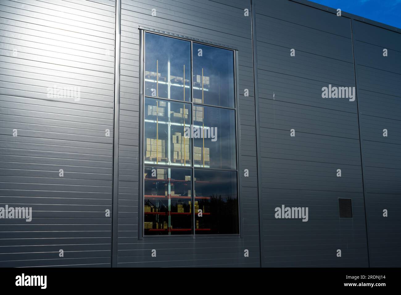 Boxes and pallets visible through a window at a large warehouse Stock ...