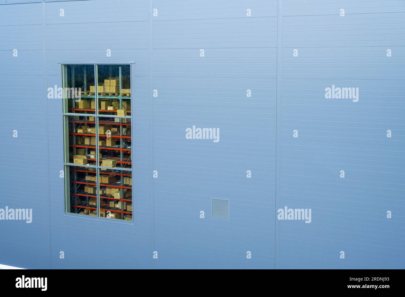 Boxes and pallets visible through a window at a large warehouse Stock ...