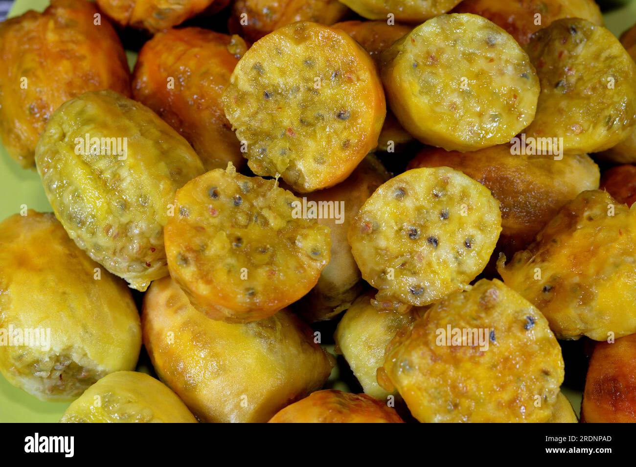 A pile of peeled fresh prickly pear fruit in a plate isolated on wooden ...