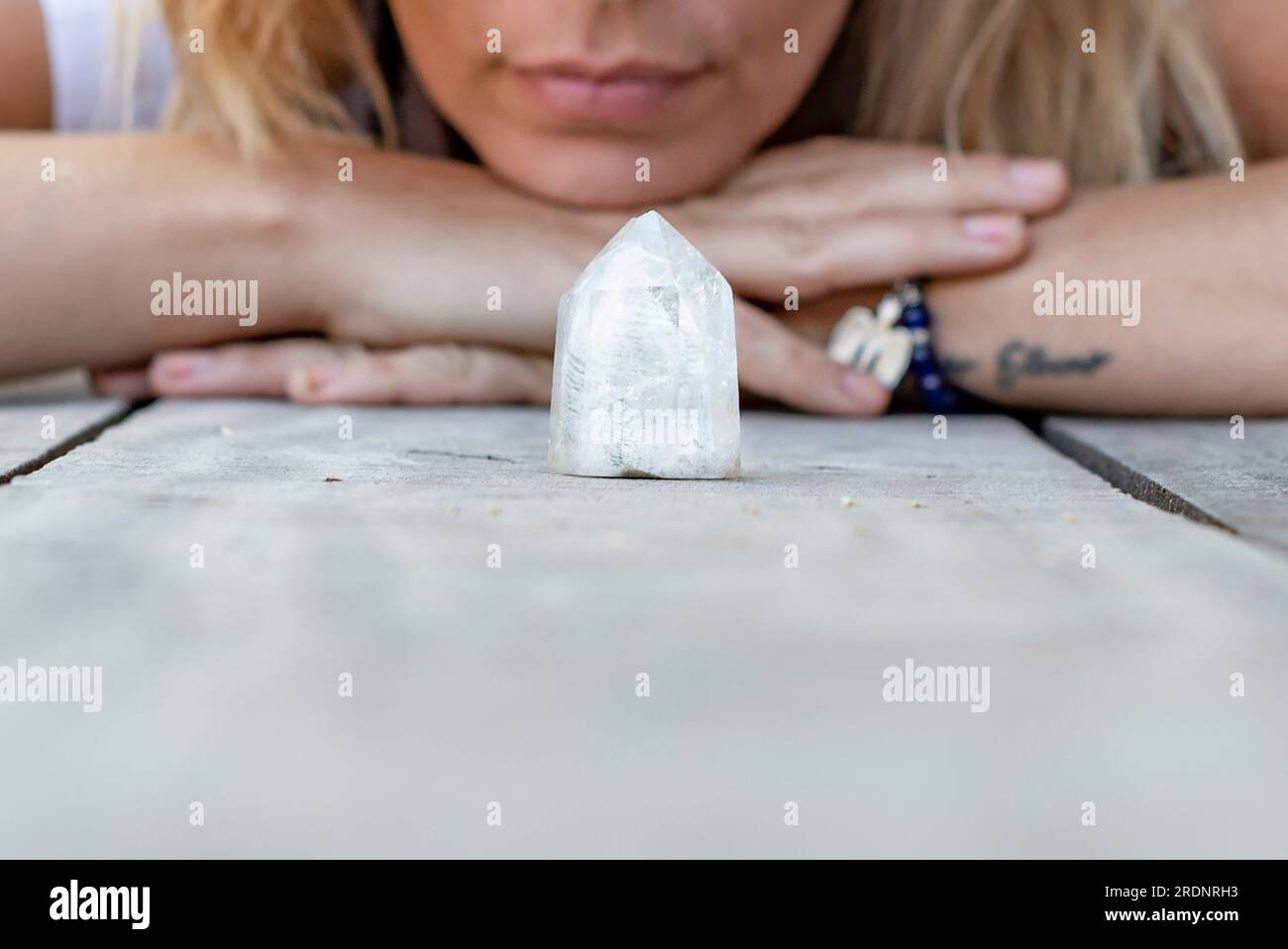 Close up of a white quartz crystal with a woman behind Stock Photo - Alamy