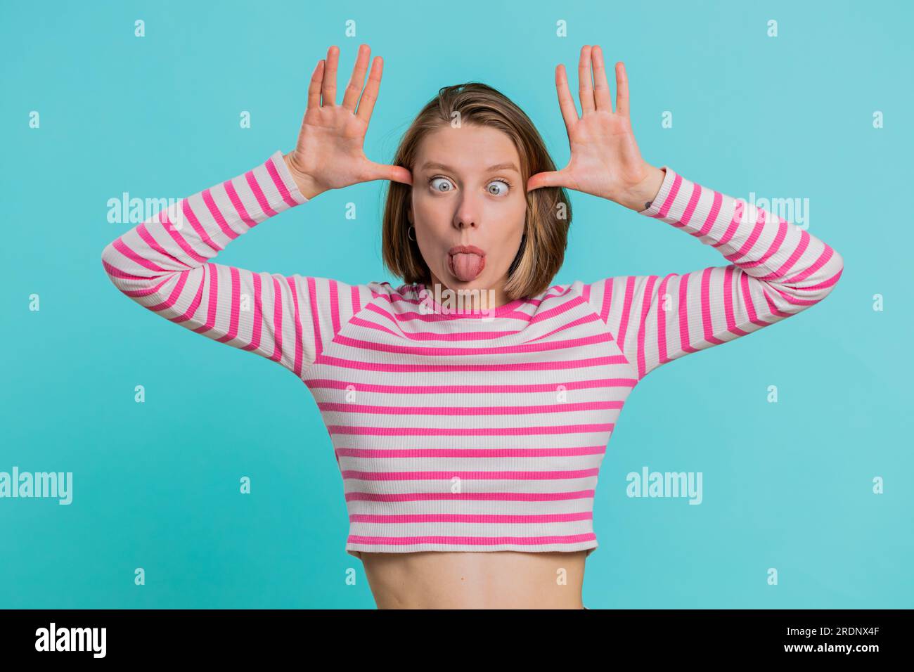 Funny comical playful young woman making silly facial expressions and ...