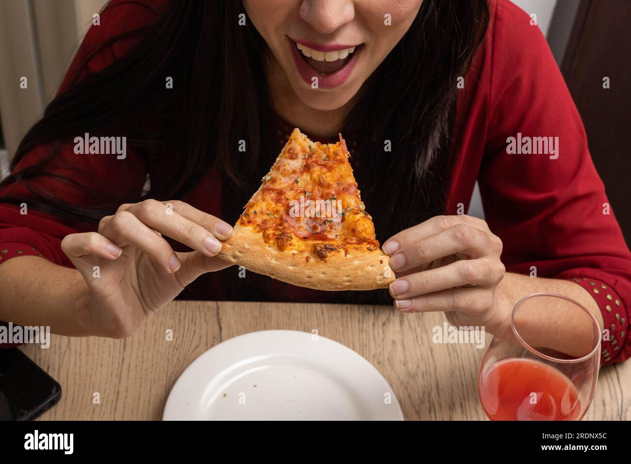 taking a bite of a piece of pizza, appetizing fast food as wallpaper in ...