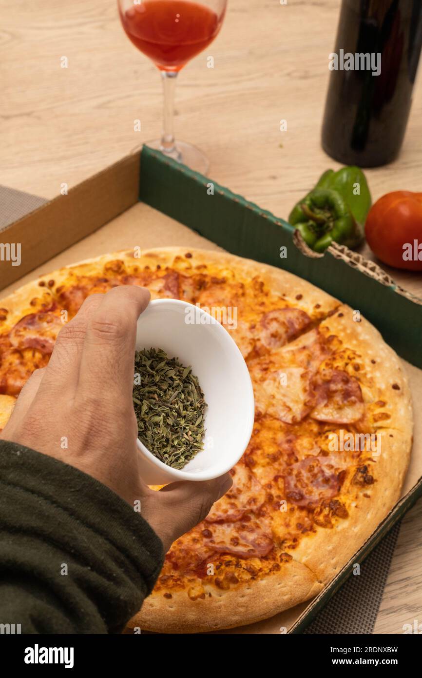 finishing preparing a pizza with oregano, delicious fast food ...