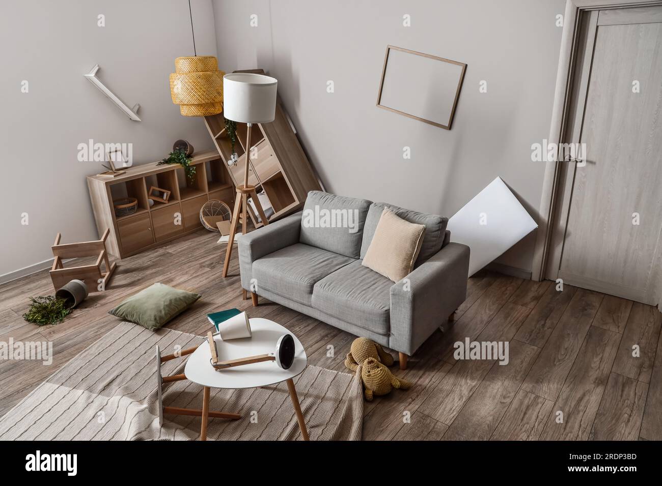 Sofa with tables and shelving units in messy living room Stock Photo ...