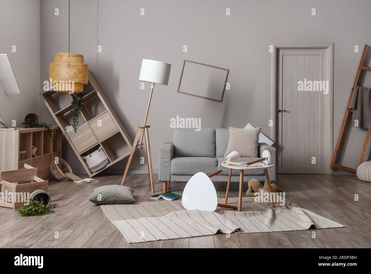 Sofa with tables and shelving units in messy living room Stock Photo ...