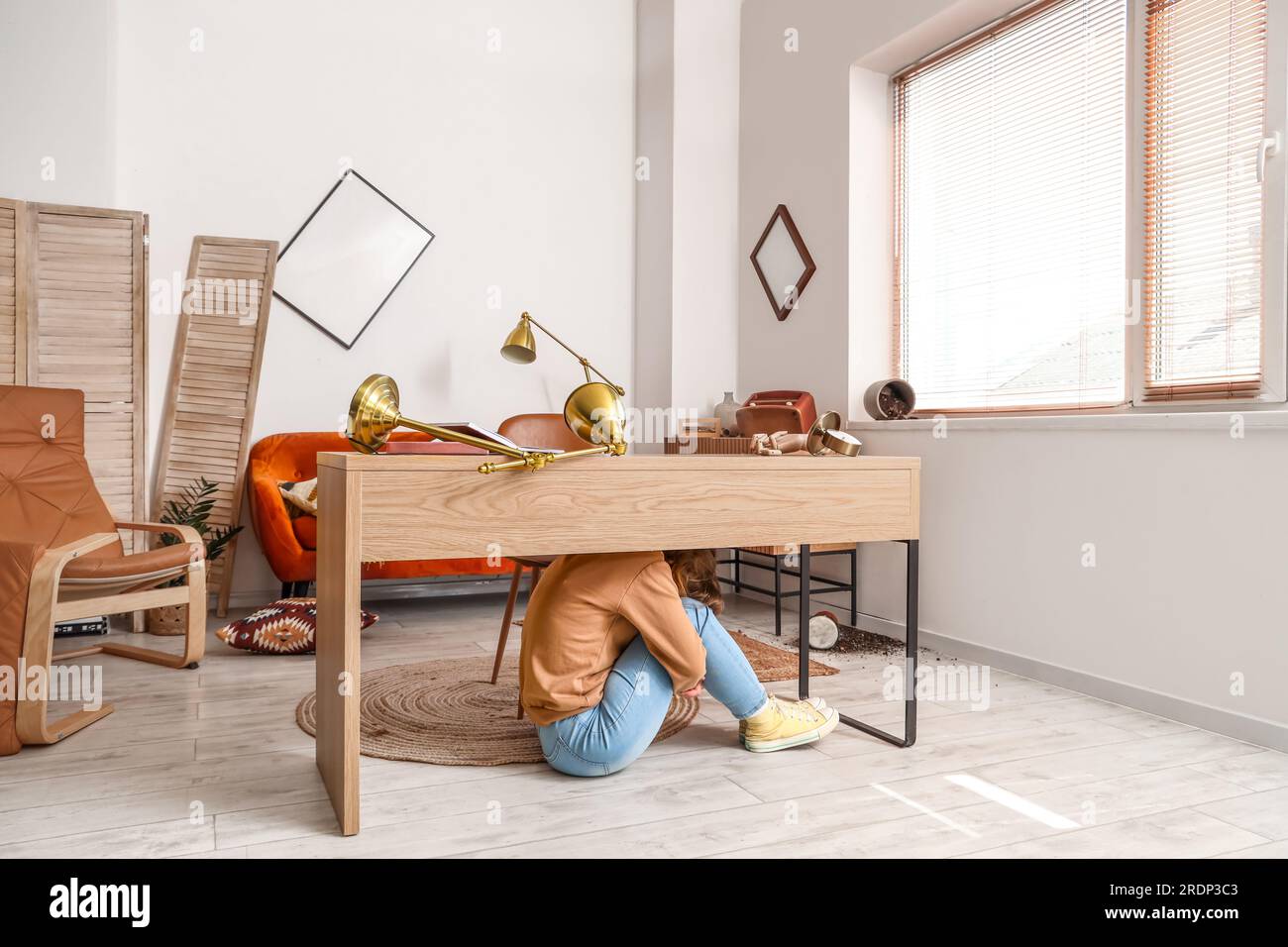 Young woman hiding under table during earthquake in office Stock Photo ...
