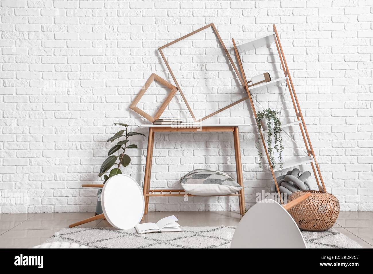 Tables with frames and shelving unit in messy living room Stock Photo ...