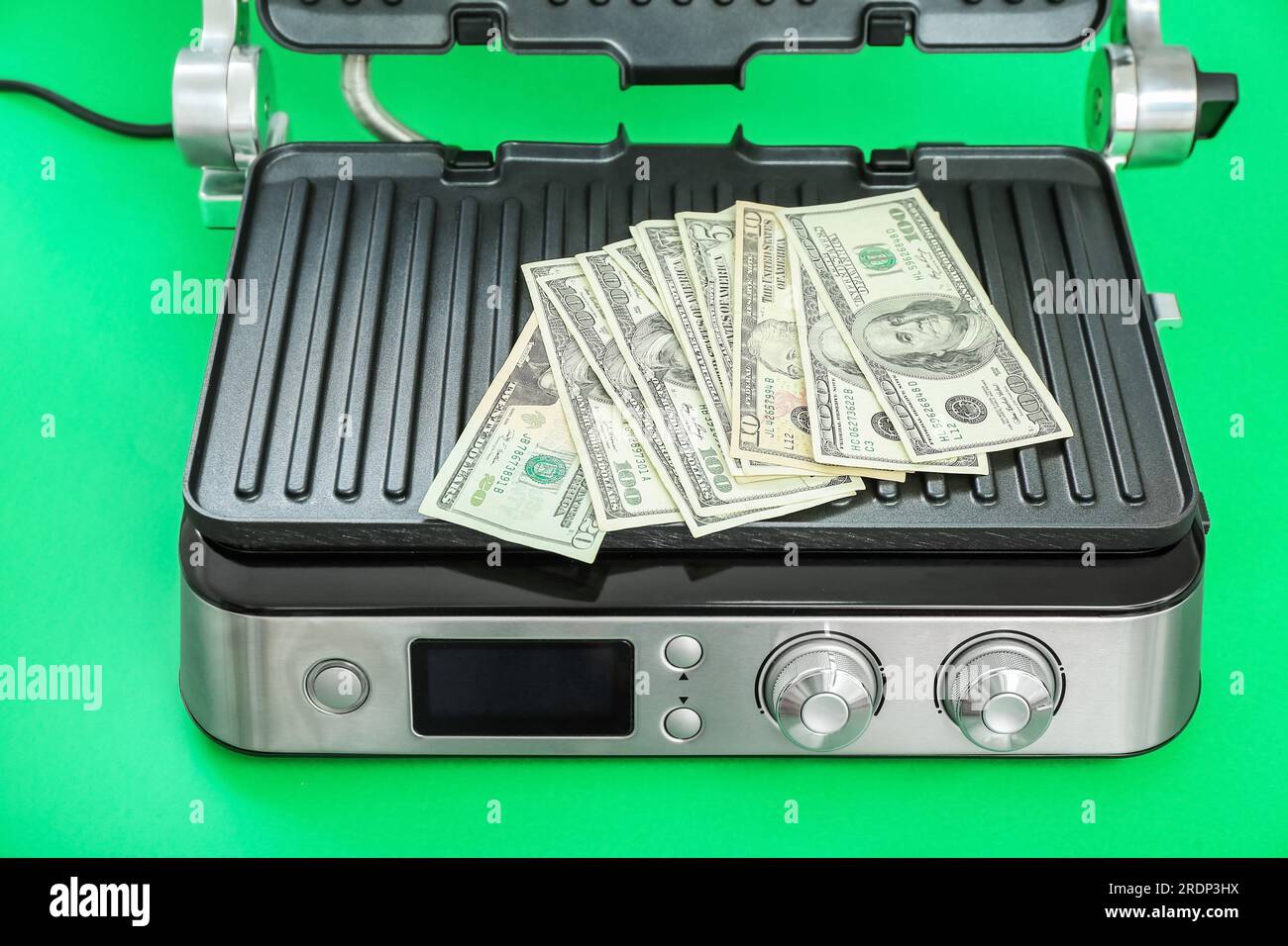 Electric grill with dollar banknotes on green background Stock Photo ...