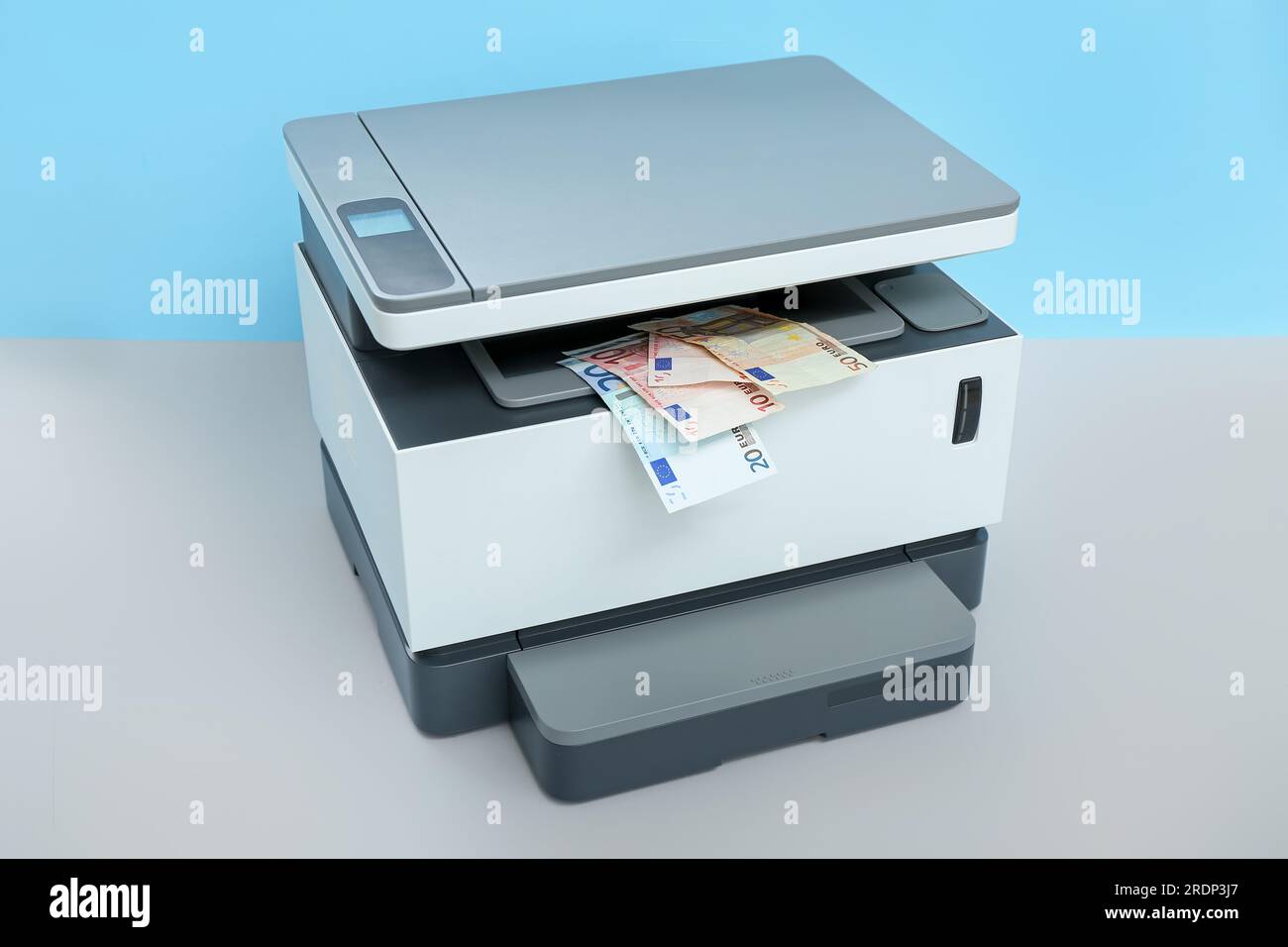 Laser printer with euro banknotes on table near blue wall Stock Photo ...