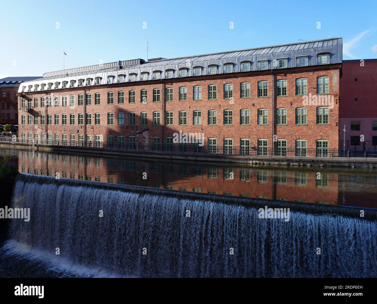 A waterfall next to industrial buildings Stock Photo - Alamy