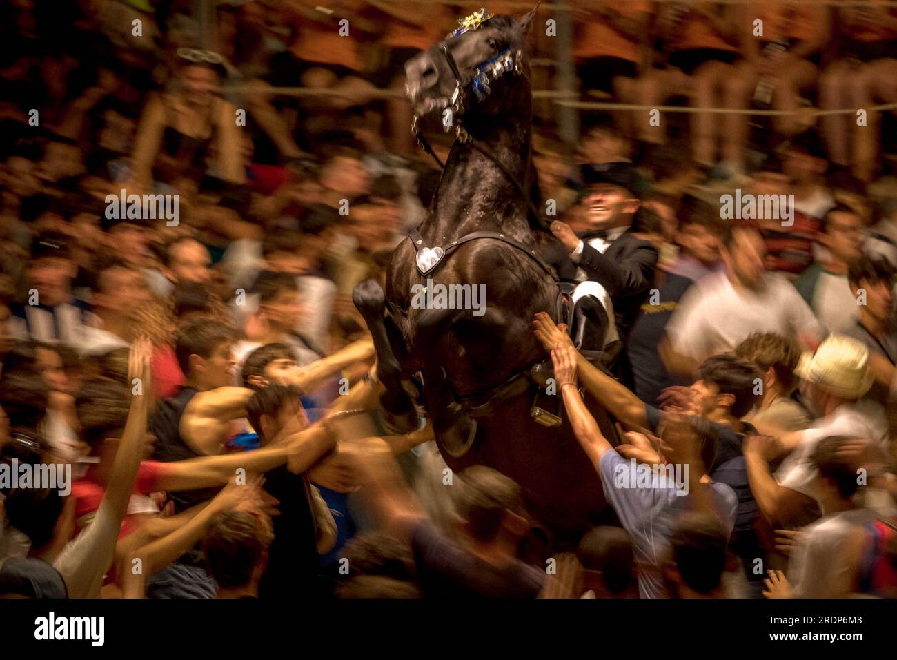 Fornells, Spain. 22nd July, 2023. A 'caixer' (horse rider) rears up on his horse surrounded by a ...