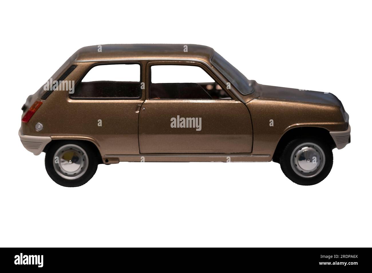 A compact two door car in brown with shiny chrome hubcaps, circa 1960s ...