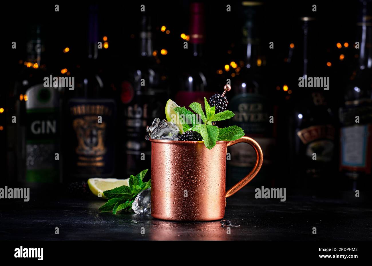 Blackberry Moscow mule alcoholic cocktail drink in copper mug with lime ...