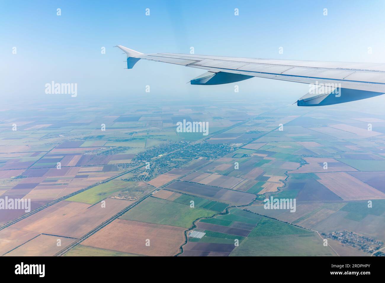 Aerial view from airplane window above green ground. View from the ...