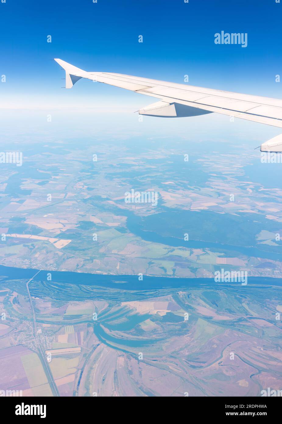 Aerial view from airplane window above green ground. View from the ...