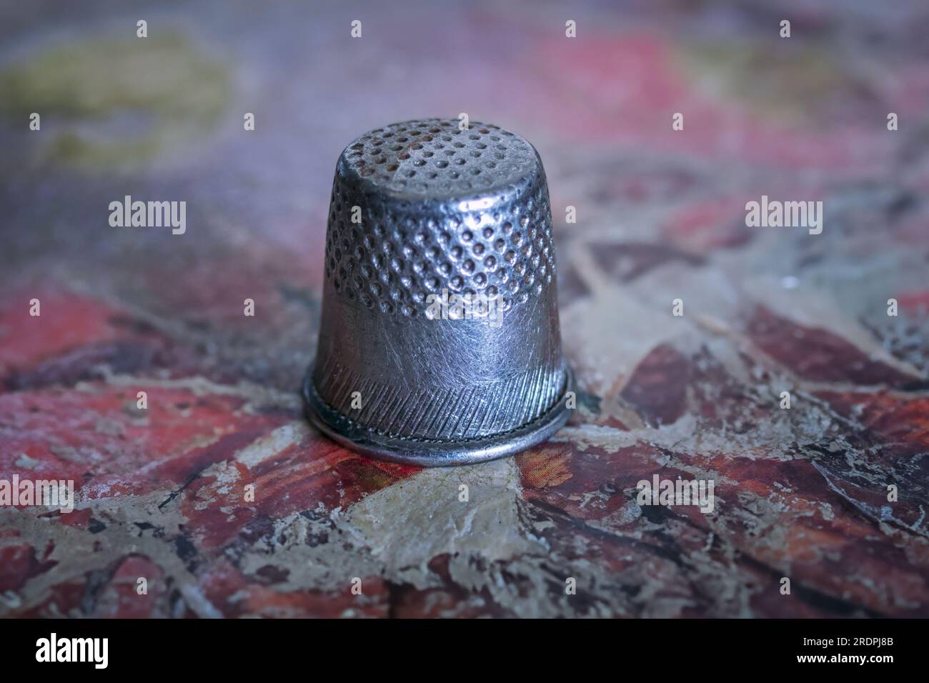 Metal thimble for sewing. Antique copper thimble on a stone background ...