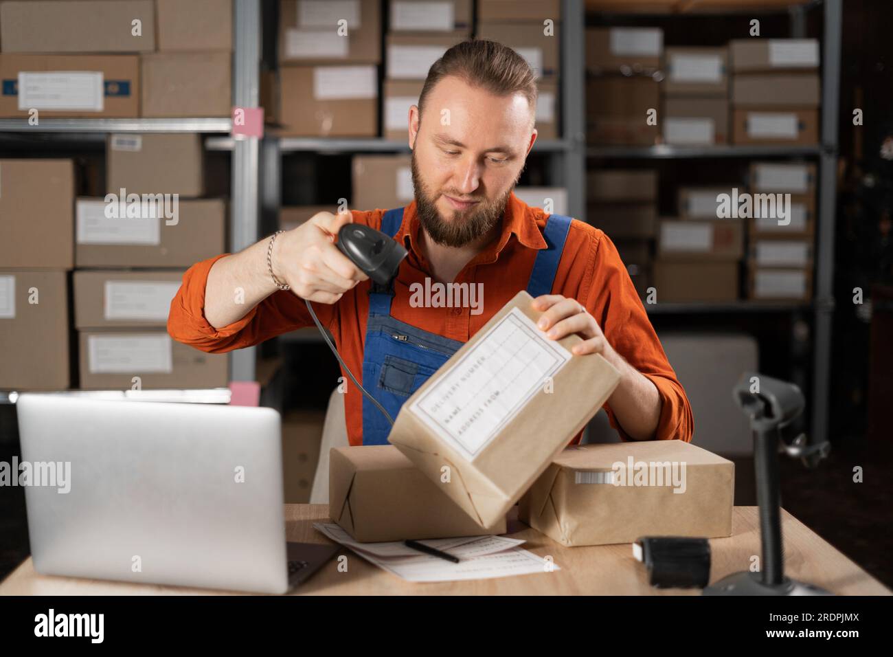 Warehouse male worker scanning bar code scanner on package boxes ...