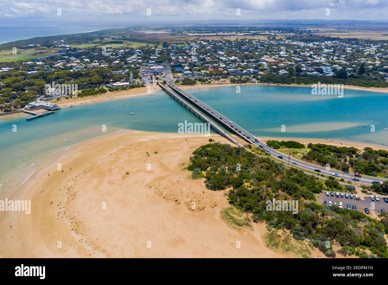 Aerial view of twin bridges over a coastal river mouth connecting a ...
