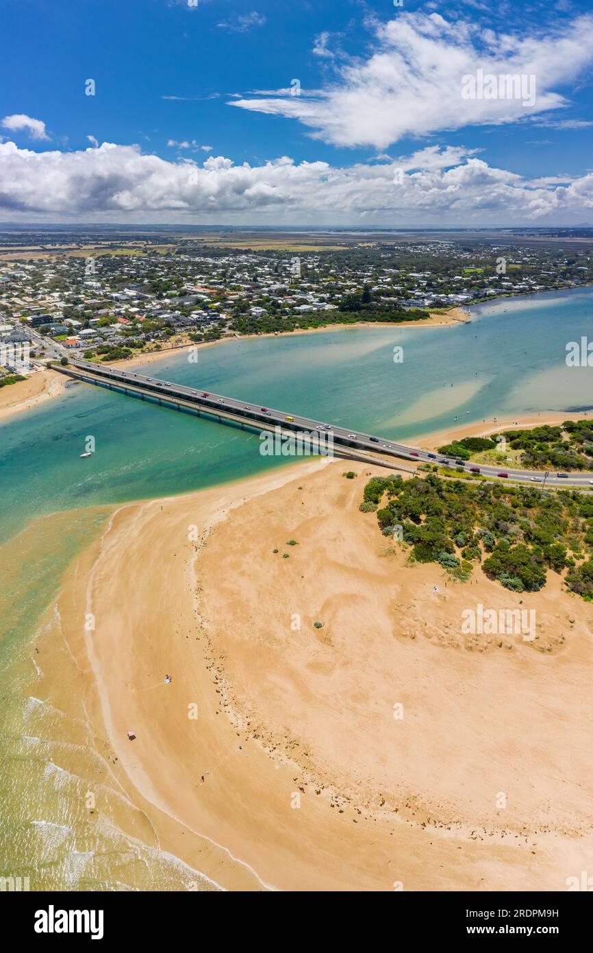 Aerial view of twin bridges over a coastal river mouth connecting a ...