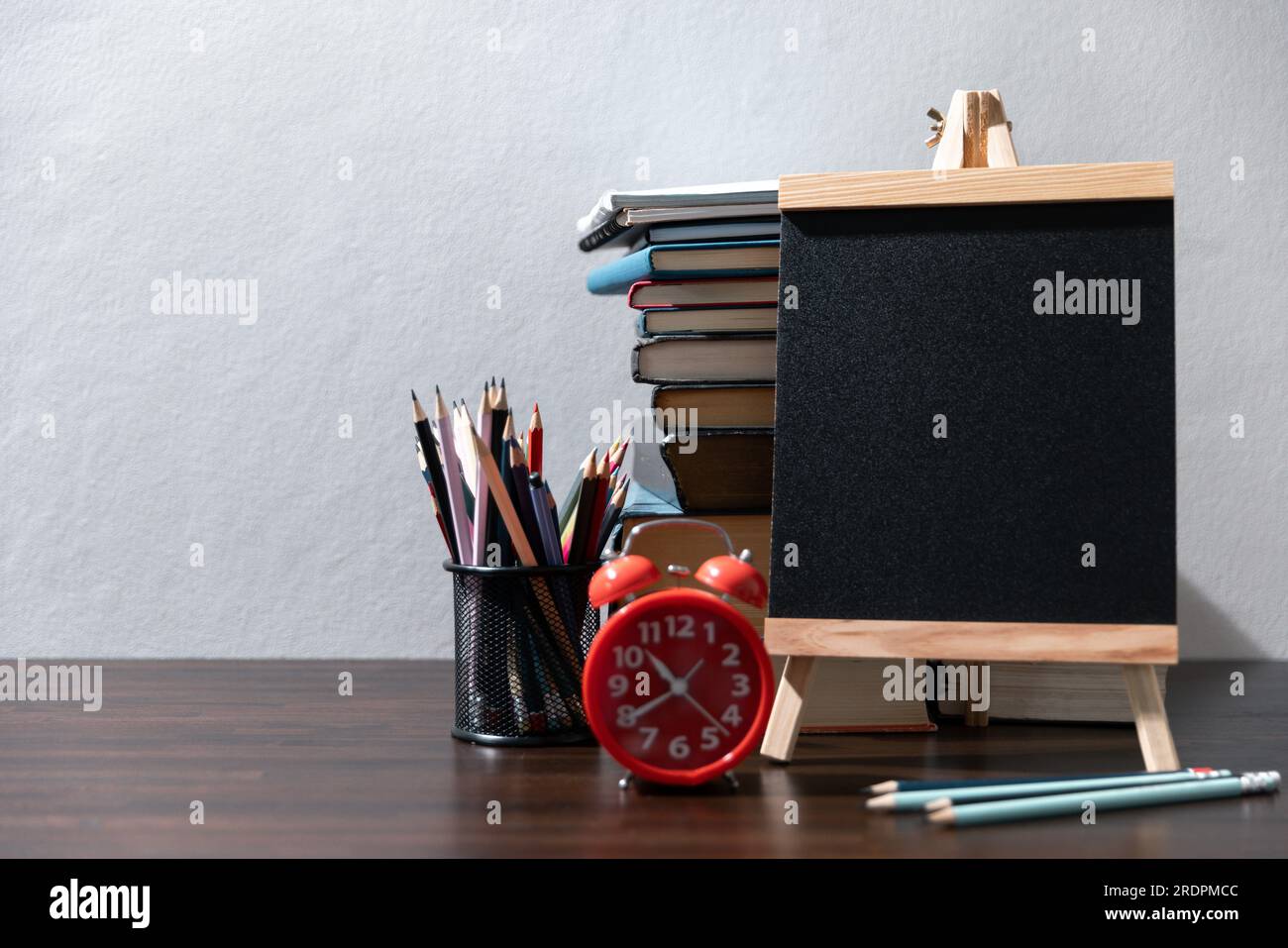 Back to school background with books on wooden table over chalkboard ...