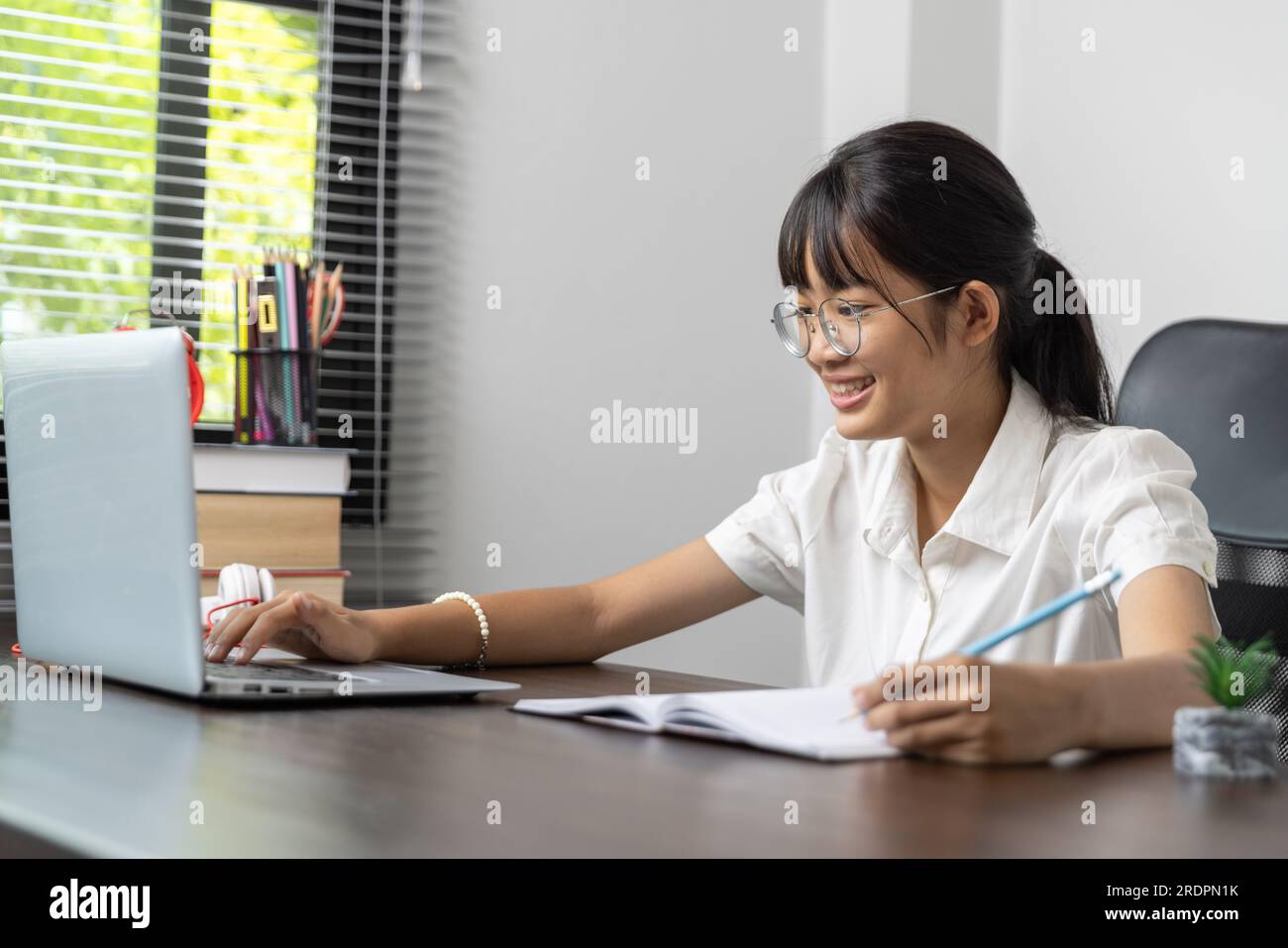 School age student doing her homework with digital tablet at home ...
