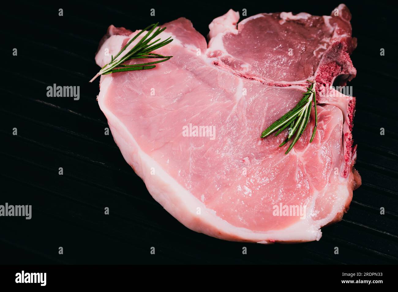 Top view raw pork chop steak on black grill background Stock Photo - Alamy