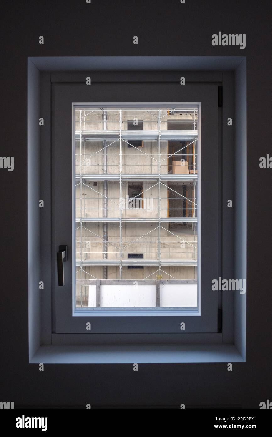 View from a dark room through a small window at the building being ...