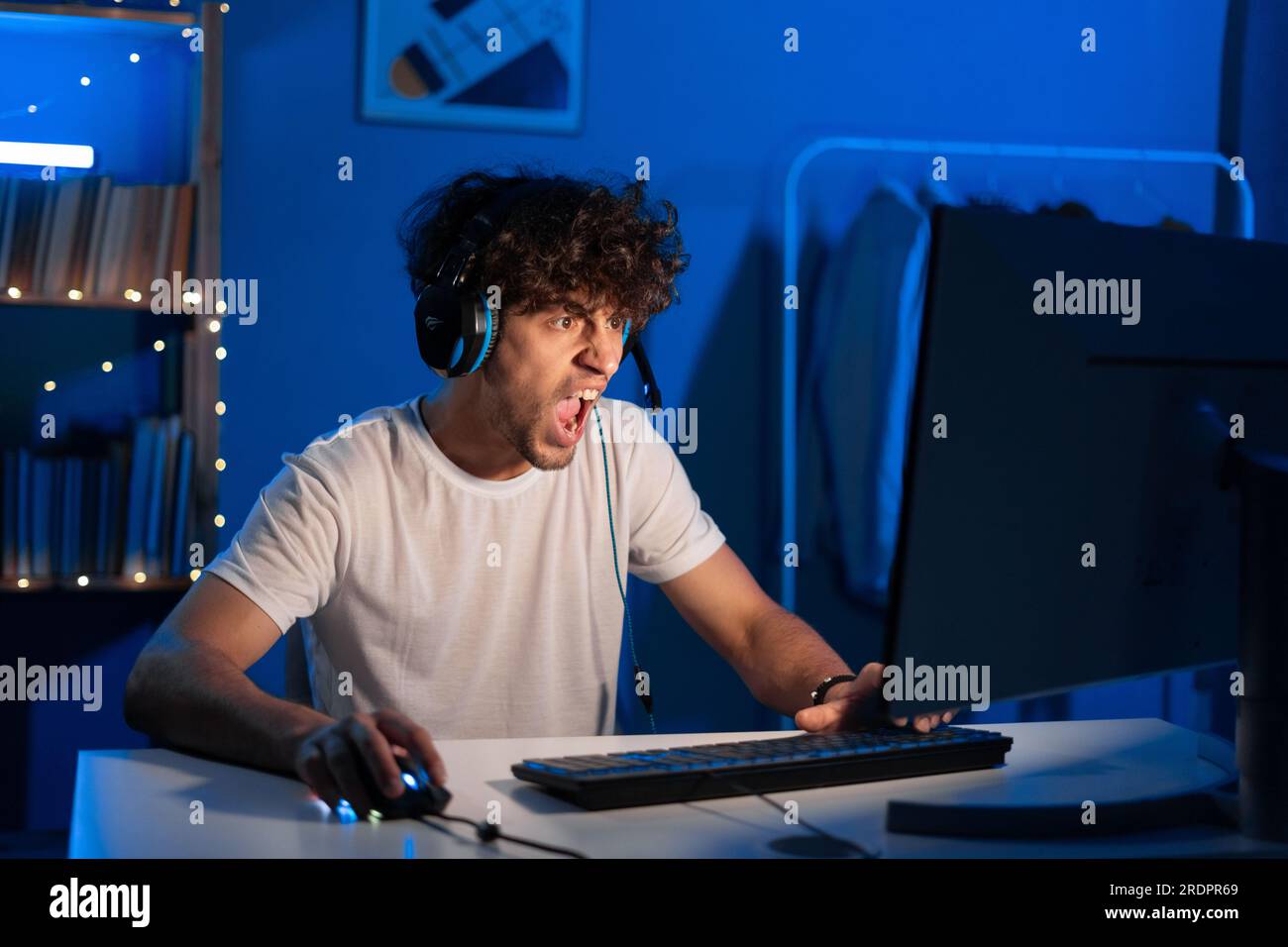 Young arabic gamer wearing headphones playing video game on personal ...