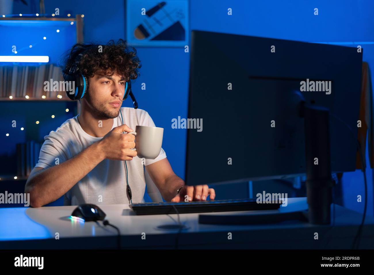 Young arabic gamer wearing headphones playing video game on personal ...
