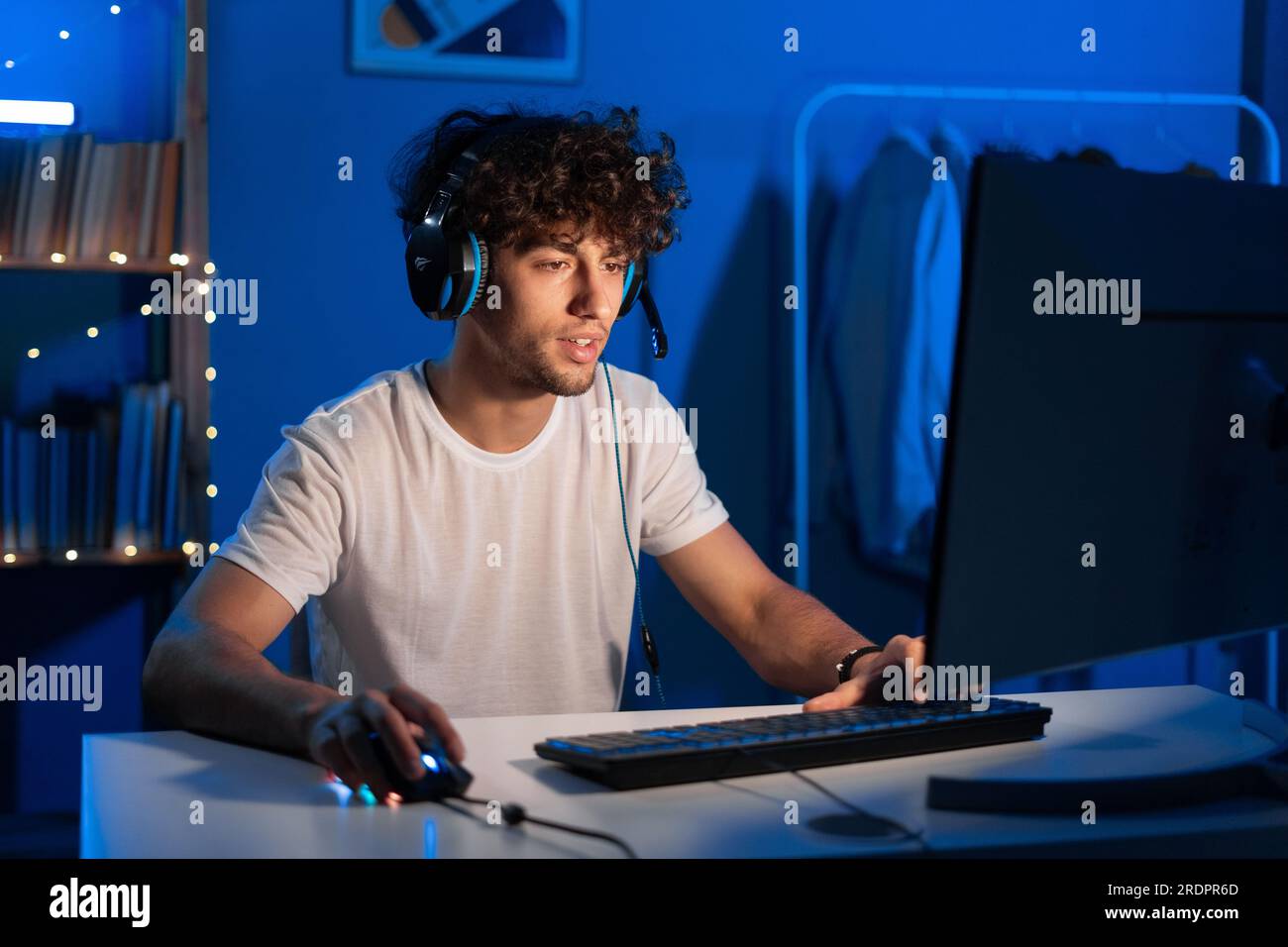 Young arabic gamer wearing headphones playing video game on personal ...